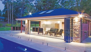 A contemporary cabana ties together this decadent pool and backyard