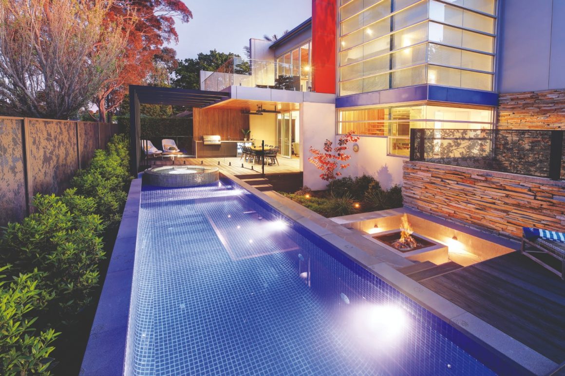 A beautiful outdoor space with an elevated glass tiled circular spa
